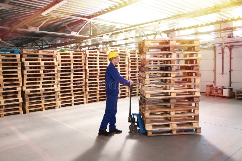 Worker Moving Wooden Pallets with Manual Forklift in Warehouse Stock ...