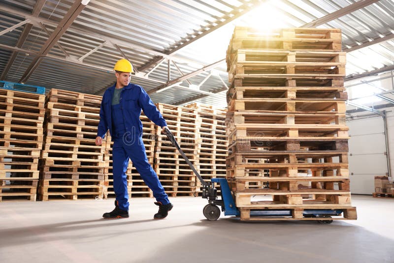 Worker Moving Wooden Pallets with Manual Forklift in Warehouse Stock ...
