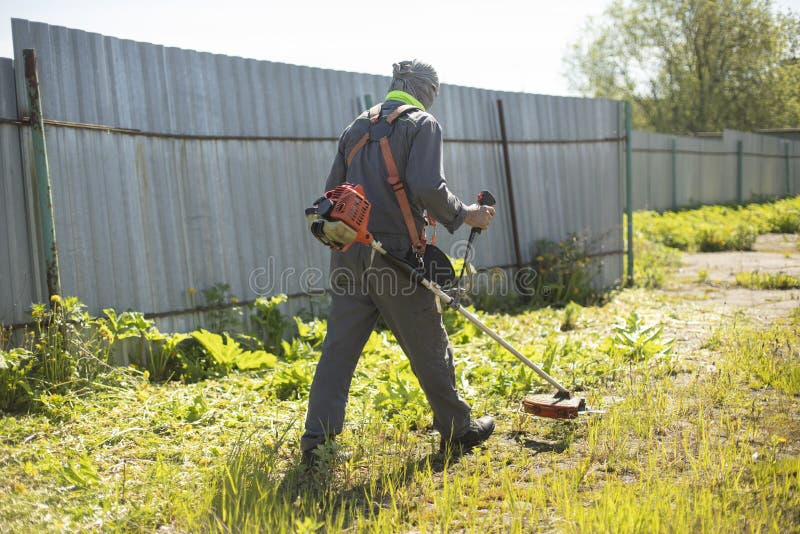 Worker Mows Lawn. Gardener with Gasoline-powered Lawn Mower Stock Image ...