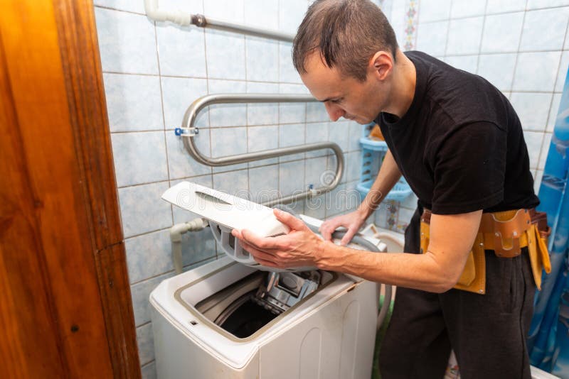 A Worker and an Old Washing Machine Stock Photo - Image of hand ...