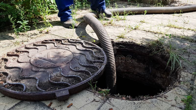 The Worker Opened the Sewer Hatch and Inserted a Hose for Cleaning the ...