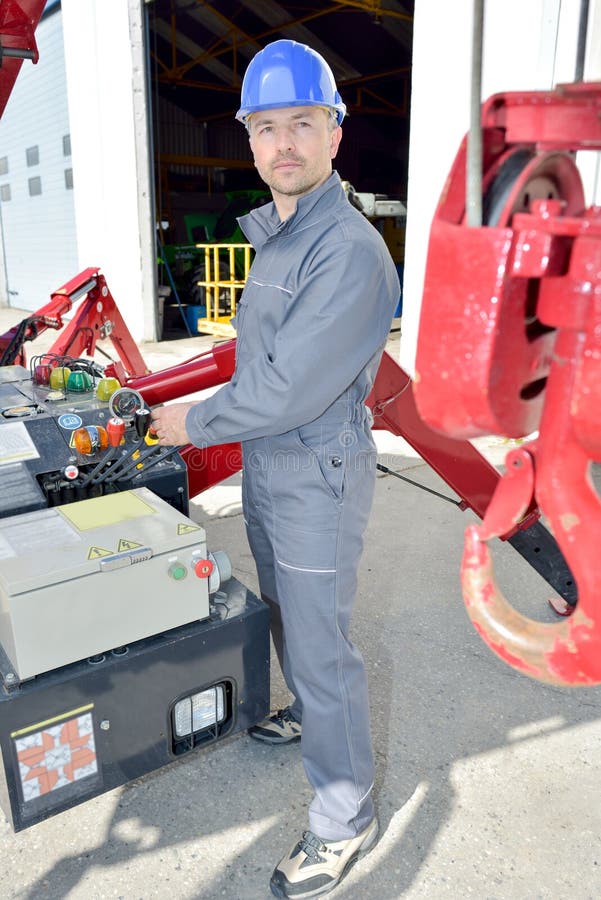 Worker Operating Crane at Construction Site Stock Photo - Image of ...