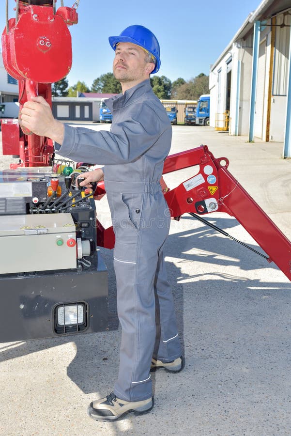 Worker Operating Crane at Construction Site Stock Photo - Image of ...