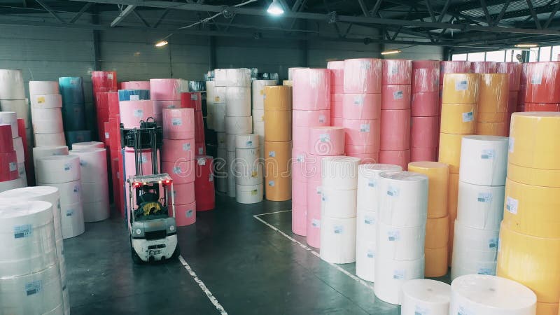 Worker Operating a Forklift Loader To Move Large Paper Rolls at a ...