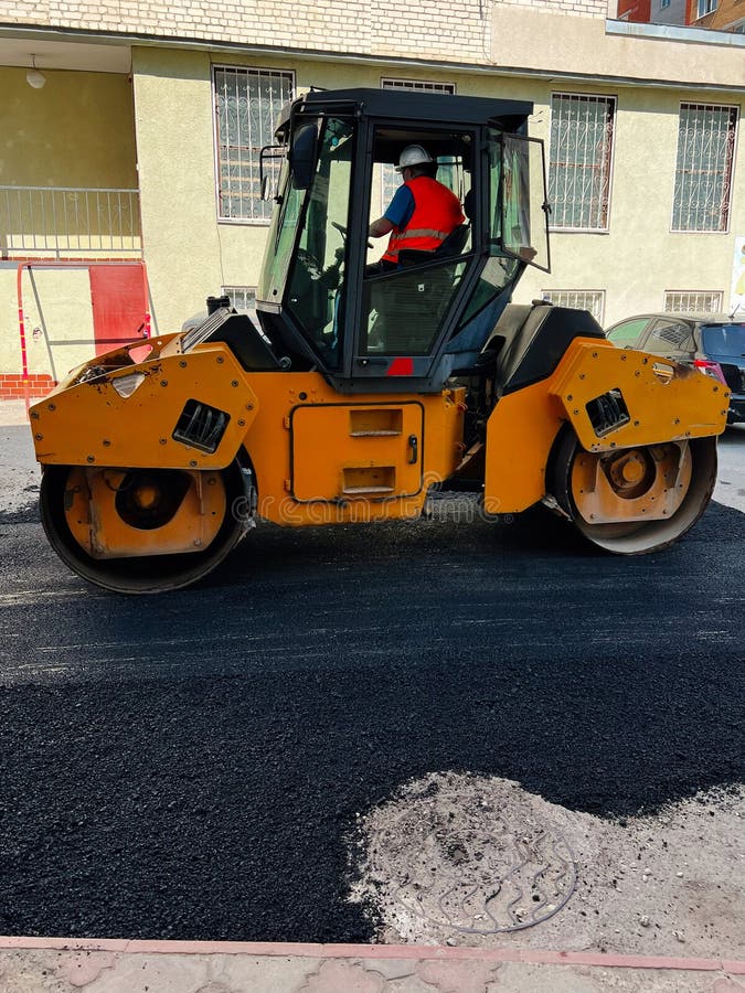 Worker Operating a Yellow Roller in an Urban Construction Area Stock ...