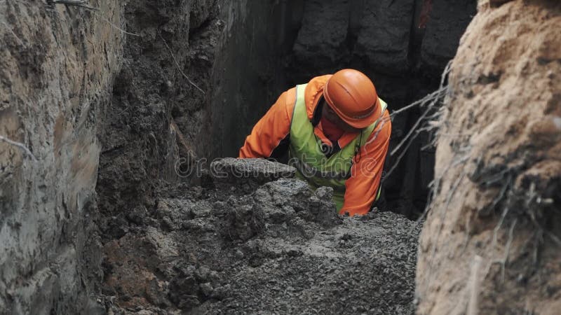 Worker in Orange Hard Hat Digging Soil in Trench with Shovel at ...