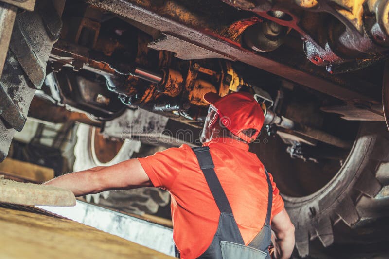 Mechanic Inspecting Heavy Machinery Components in a Workshop during ...