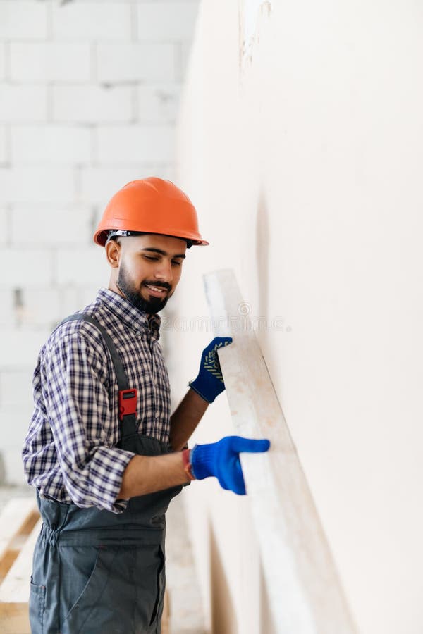 A Worker in Overall and Cap, Holding a Comb Putty-knife and Covering a ...