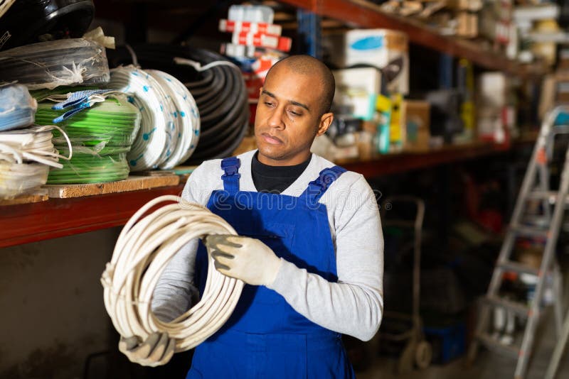 Worker in Overalls Selects an Electrical Cable at Hardware Store Stock ...