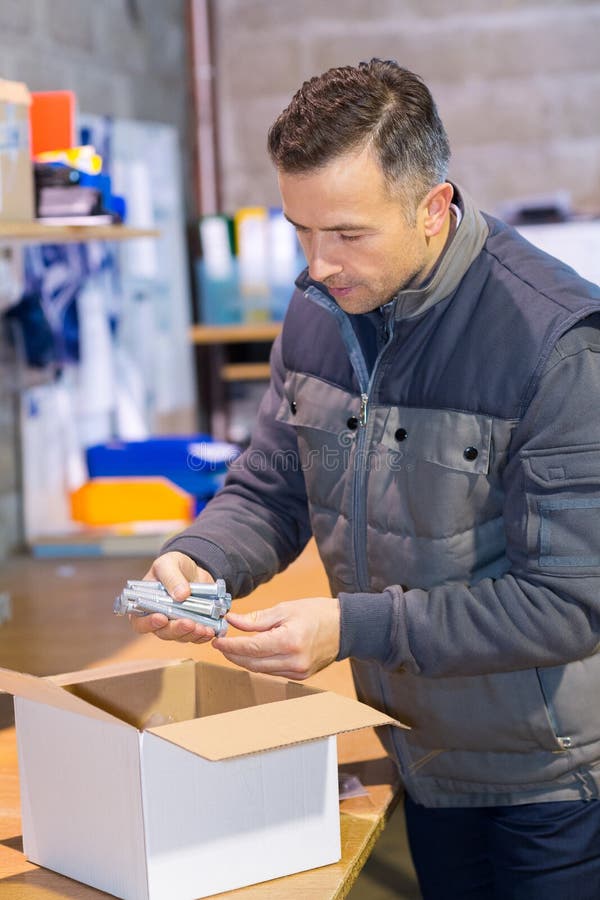 Worker Packaging Order for Metal Bolts into Cardboard Box Stock Photo ...