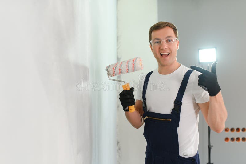 Worker Painter Paints a Wall. Professional Builder Makes Repairs. Stock ...