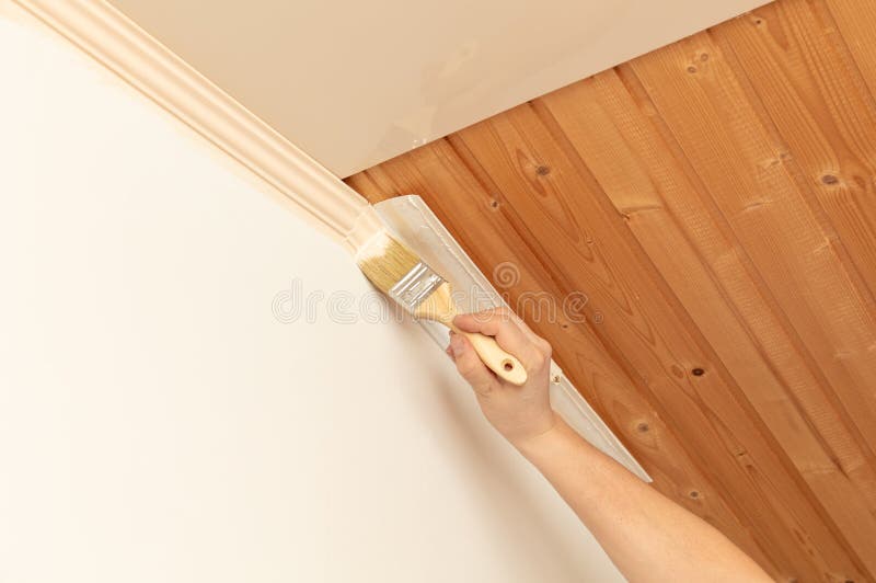 A Worker Paints Moldings on the Ceiling with a Brush. Home Renovation ...