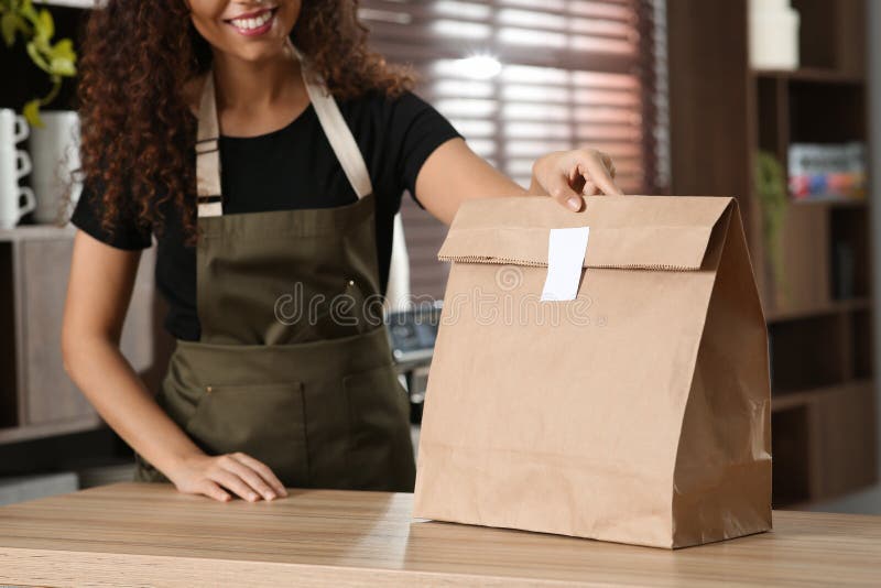 Worker with Paper Bag at Counter in Cafe, Closeup Stock Photo - Image ...
