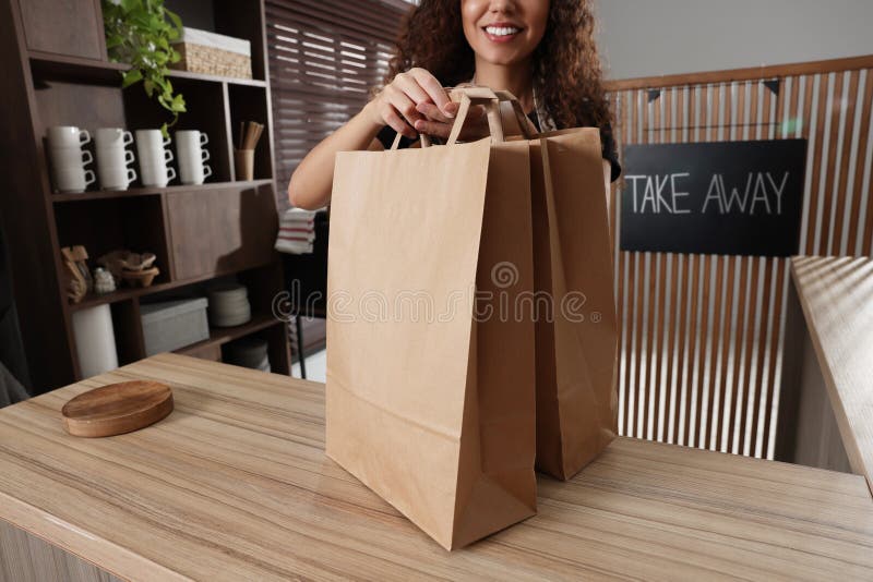 Worker with Paper Bags at Counter in Cafe, Closeup Stock Image - Image ...