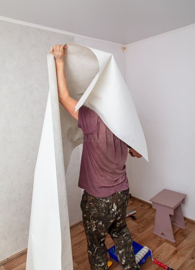A Worker Pastes Wallpaper on the Walls in a Room Stock Image - Image of ...