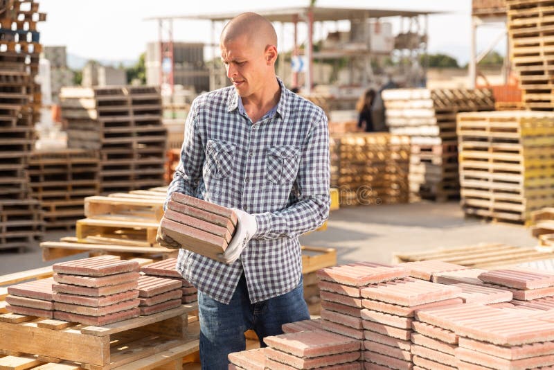 Worker Places Paving Slabs on a Pallet in Building Materials Warehouse ...
