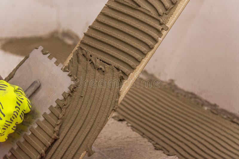 Worker Placing Ceramic Floor Tiles on Adhesive Surface, Leveling with ...