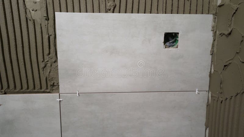 Worker Placing Large Format Tile on Bathroom Wall Using Tile Leveling ...