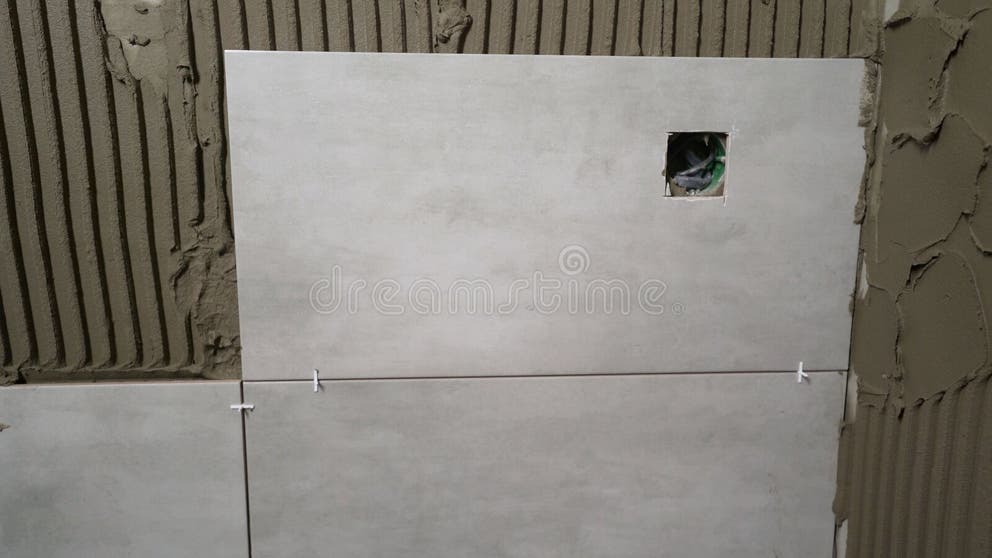 Worker Placing Large Format Tile on Bathroom Wall Using Tile Leveling ...