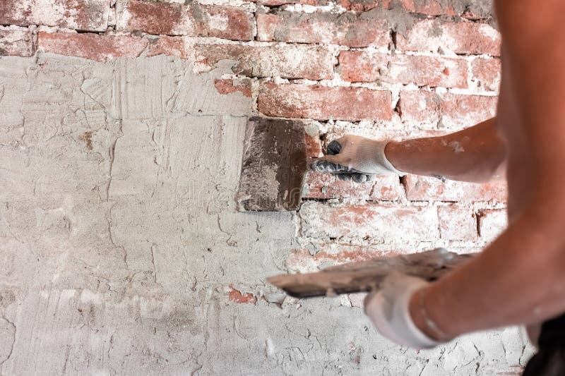 A Worker is Plastering an Old Brick Wall, Applying a Cement Mixture ...