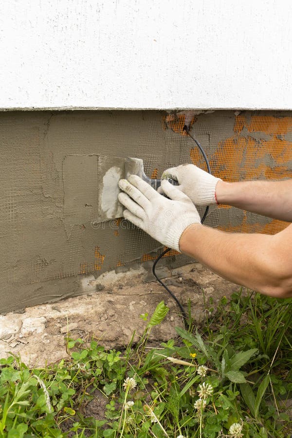 A Worker Plasters the Foundation with Cement Plaster and Glues in the ...