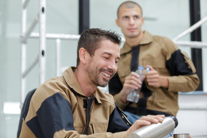 Worker Pouring Drink from Flask during Break Time Stock Photo - Image ...