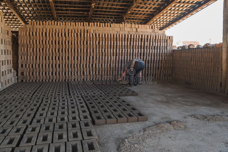 Worker Pours the Mixture of Mud, Sand and Sawdust Over Molds for Making ...