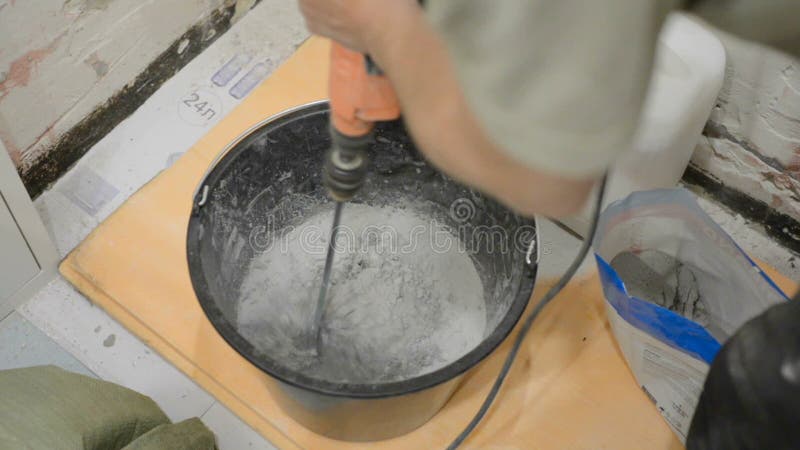The Worker Pours a Mixture of Tile Glue and Brings the Mixing Process ...