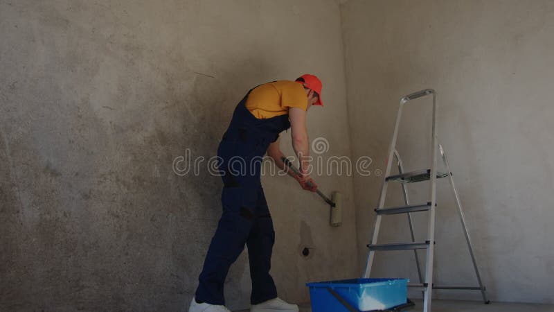 Worker Priming Interior Walls Using a Paint Roller in a Residential ...