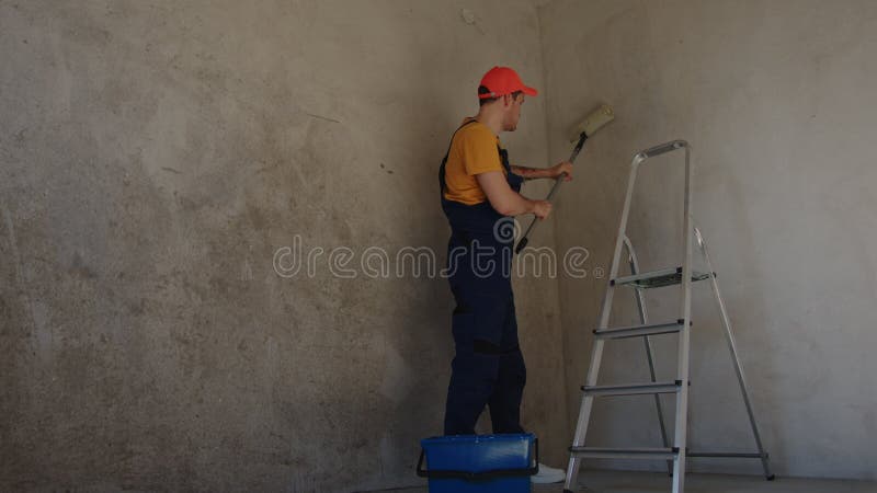 Worker Priming Interior Walls Using a Paint Roller in a Residential ...