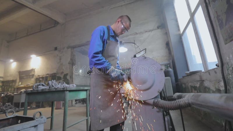 A Worker Processes a Part on a Grinding Wheel. Sparks from the Grinding ...