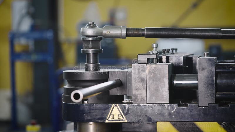 A Worker in Production Bends a Metal Pipe Using a Special Pipe Bending ...