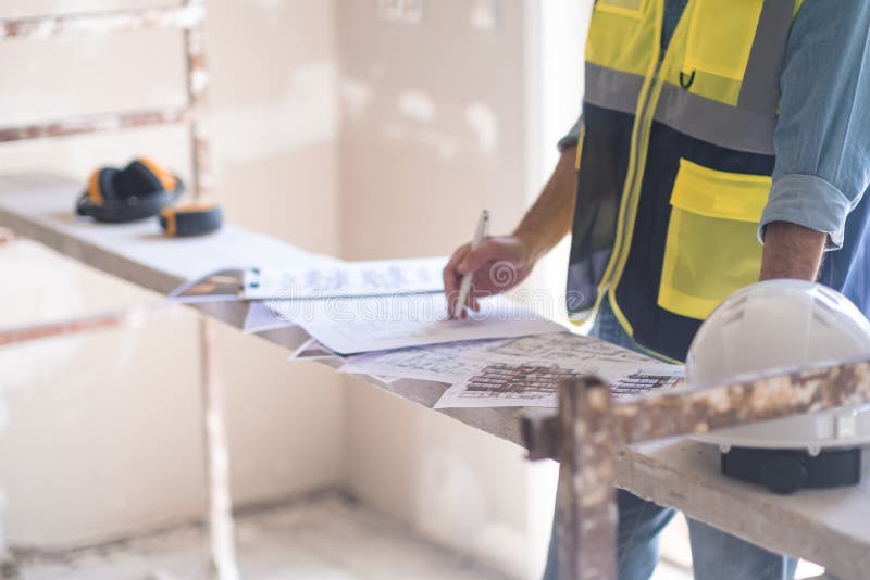 Worker in Professional Uniform Editing and Correcting Construction ...