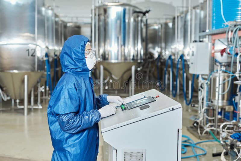 Worker in Protective Gear Operating Equipment at Factory Stock Image ...