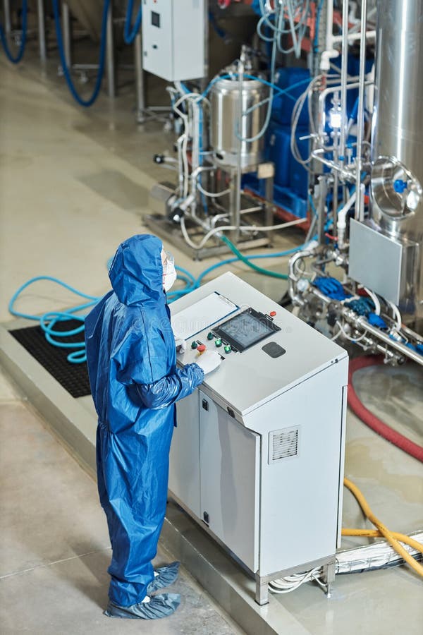 Worker in Protective Gear Operating Equipment at Factory Stock Photo ...