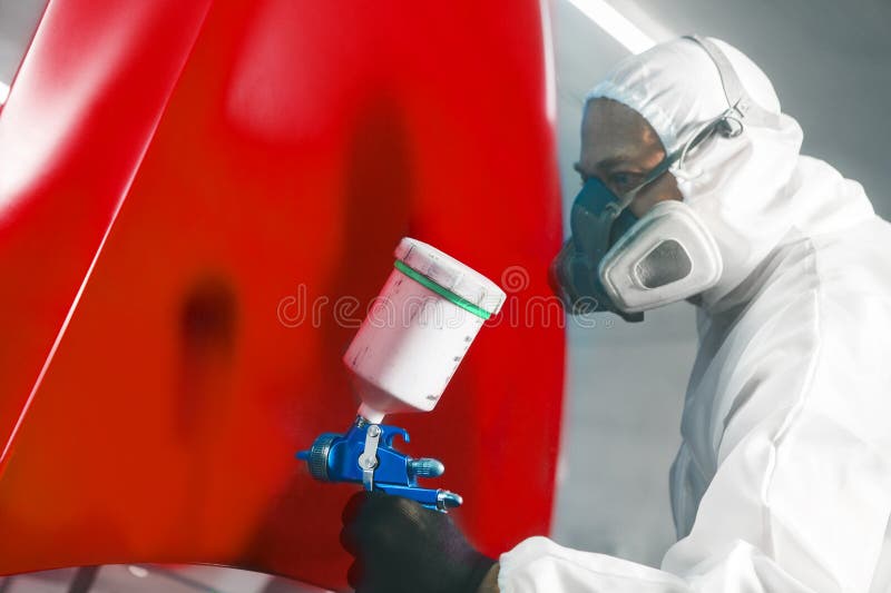 Worker in Protective Mask and Overall Spraying Base Coat of Paint on ...