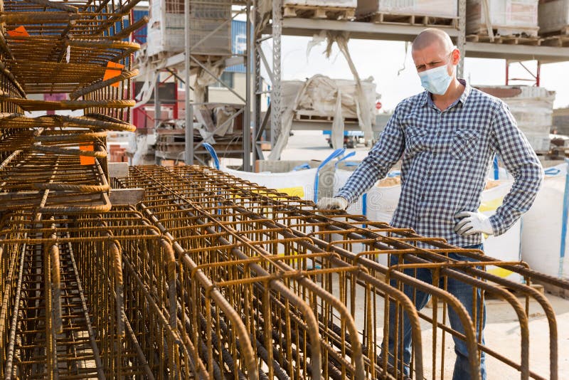 Worker in Protective Mask Prepares Metal Rebar for Loading Onto Truck ...