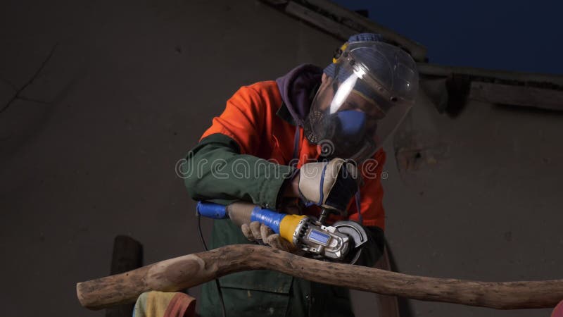 A Worker in a Protective Mask and a Respirator Cuts a Half of a ...