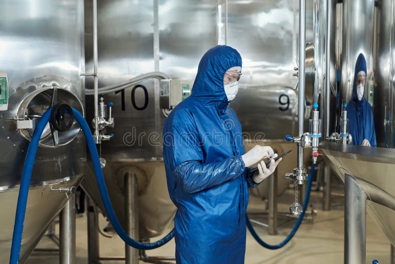 Worker in Protective Gear Operating Equipment at Factory Stock Photo ...