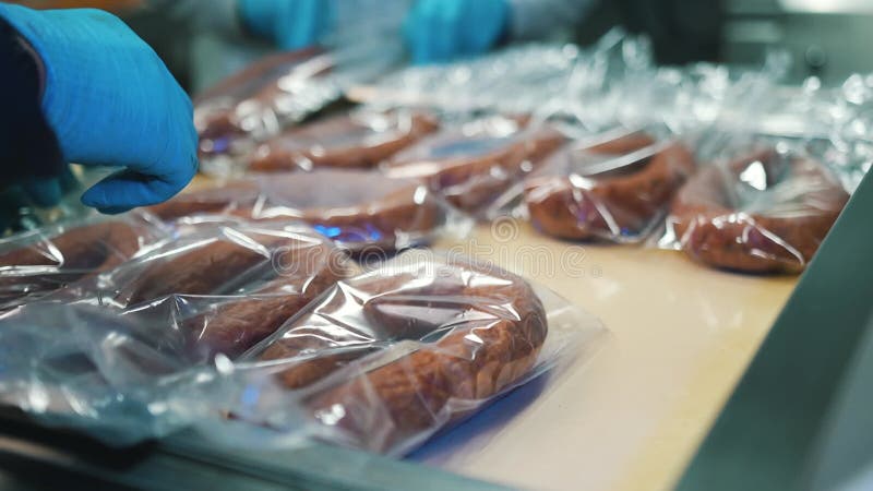 Worker in Protective Uniform Pack and Stack Sausages in Plastic ...