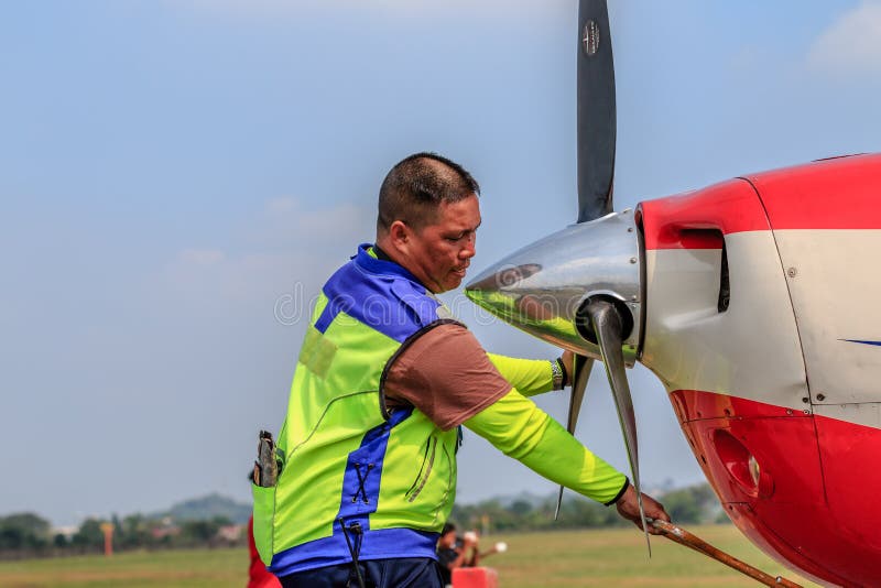 A Worker Pulling an Airplane Editorial Photo - Image of worker, plane ...