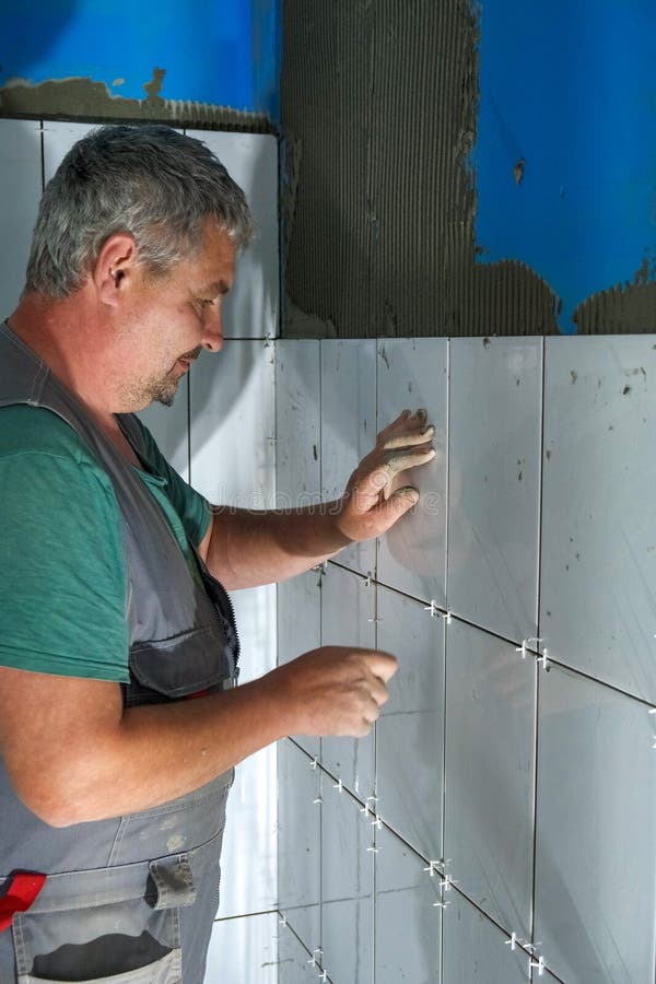 The Worker Puts Ceramic Tiles on the Construction Site Stock Photo ...
