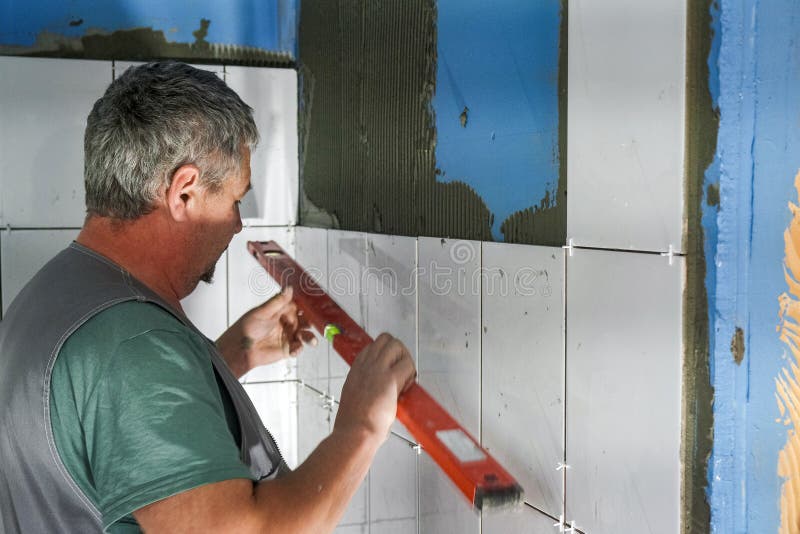 The Worker Puts Ceramic Tiles on the Construction Site Stock Photo ...