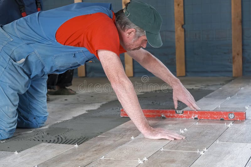 The Worker Puts Ceramic Tiles on the Construction Site Stock Photo ...