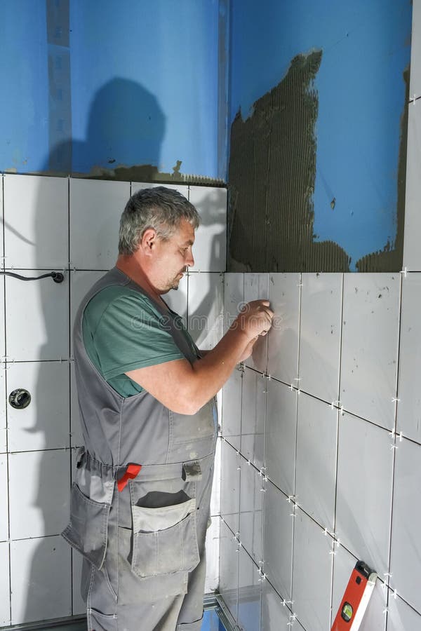 The Worker Puts Ceramic Tiles on the Construction Site Stock Photo ...