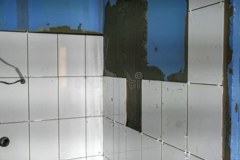 The Worker Puts Ceramic Tiles on the Construction Site Stock Photo ...