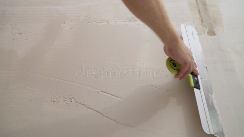 Builder Smears a Putty Knife with a Spatula. Worker Puts Mortar on a ...