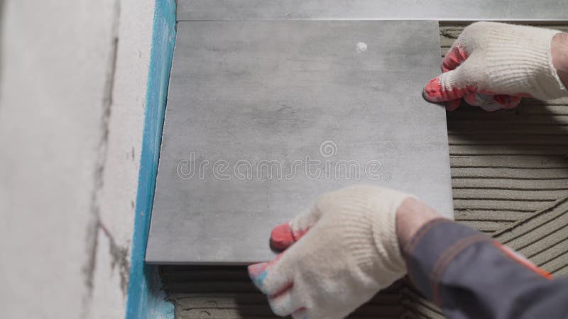 Laying Ceramic Tiles. Installing New Tiles on a Backsplash during a Home Renovation. Gluing ...