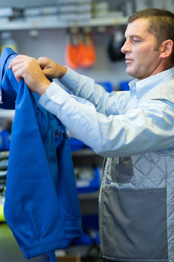 Worker Putting on Blue Coat before Starting To Work Stock Photo - Image ...