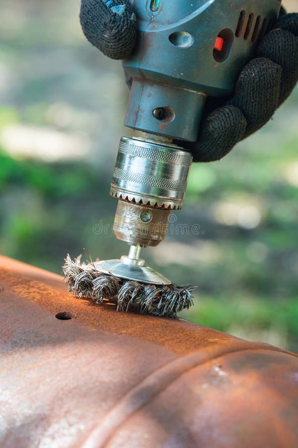 A Worker Removes Rust and Corrosion from a Metal Surface Using a Wire ...